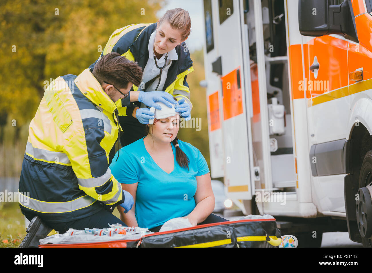 Emergency medics dressing head wound of injured woman Stock Photo - Alamy