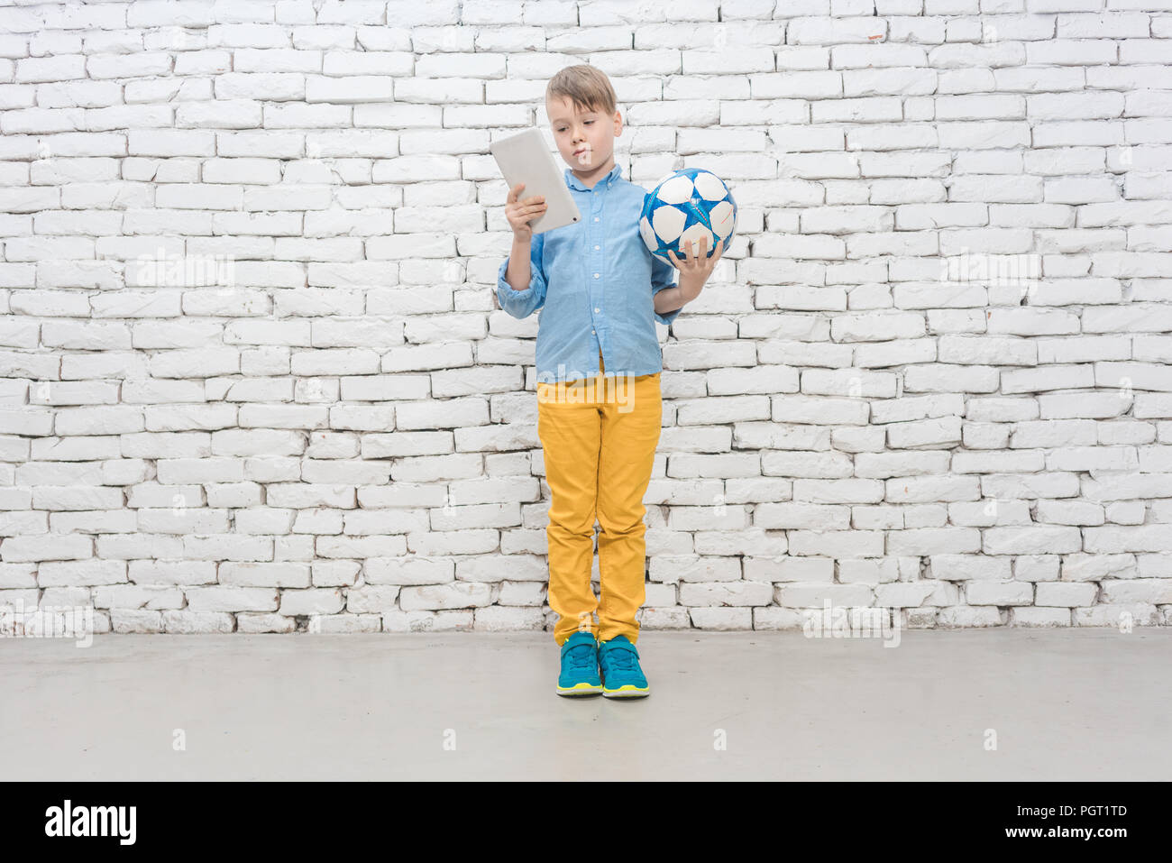 Boy has to decide between homework and football Stock Photo - Alamy