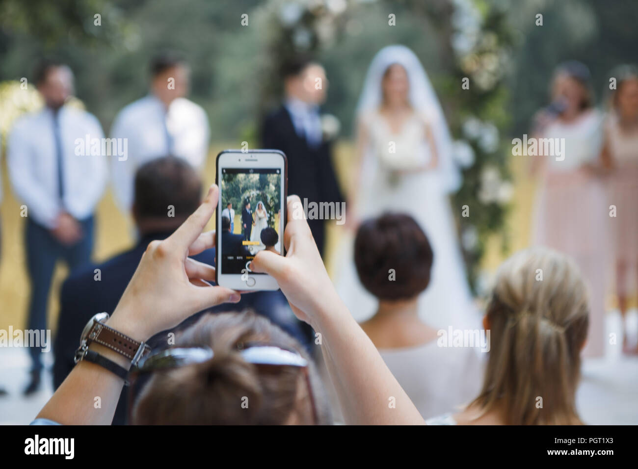 guest at the wedding ceremony takes pictures on the phone of the ...