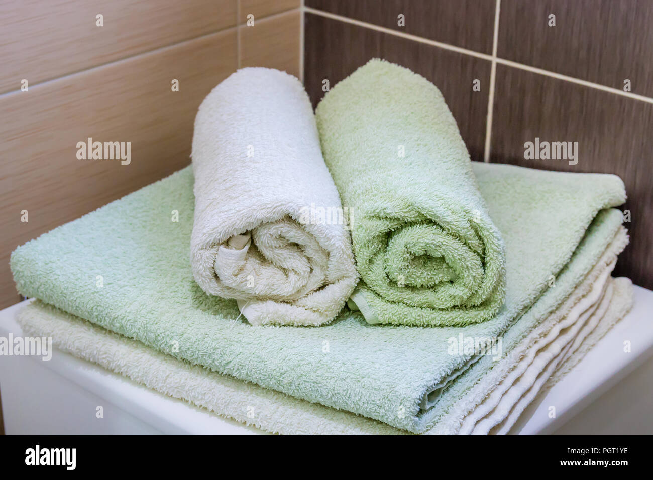 Rolled up fluffy spa towels on the shelf in modern bathroom interior ...