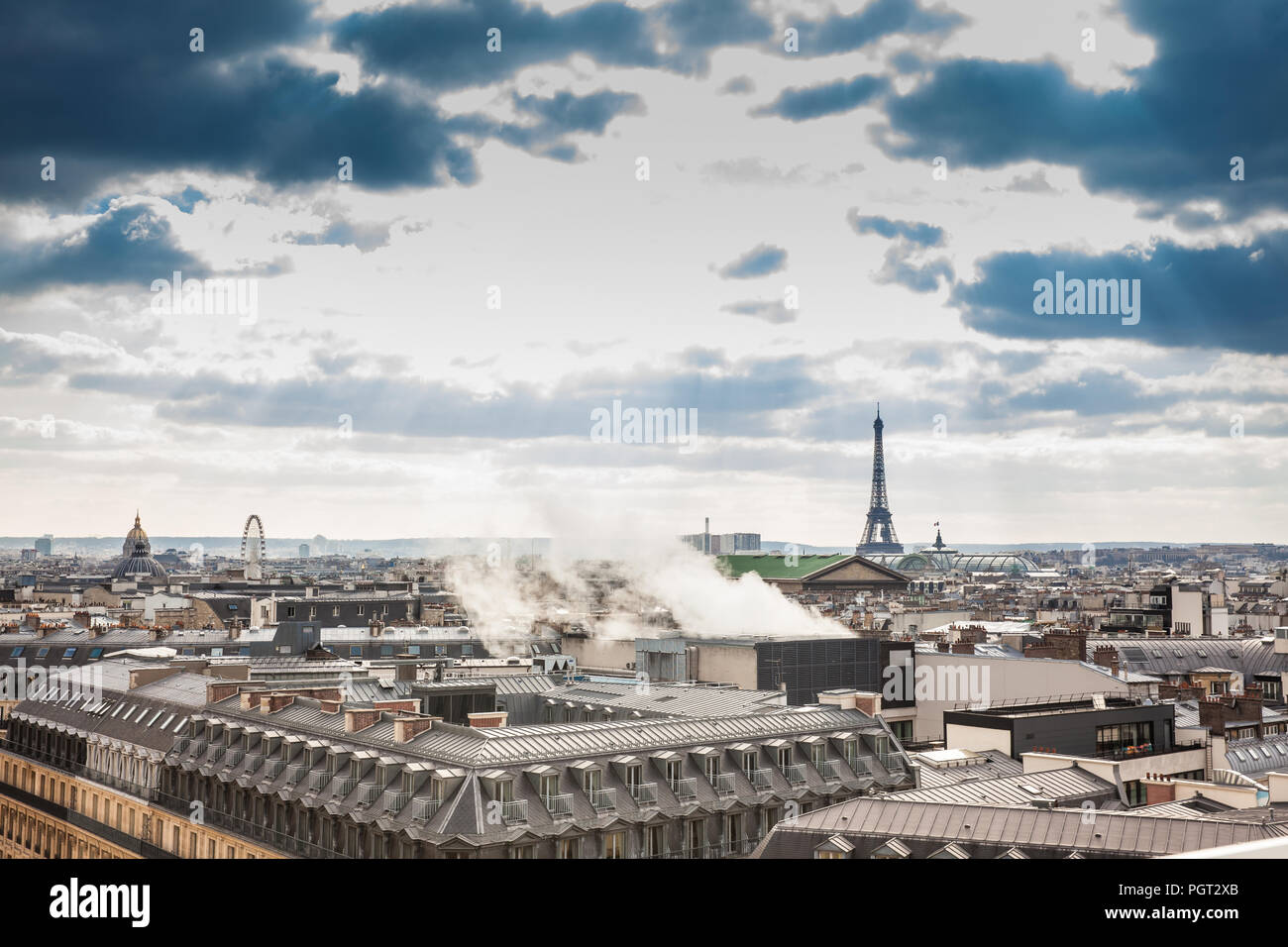Sun rays over the beautiful Paris City seen from a rooftop in a cold ...
