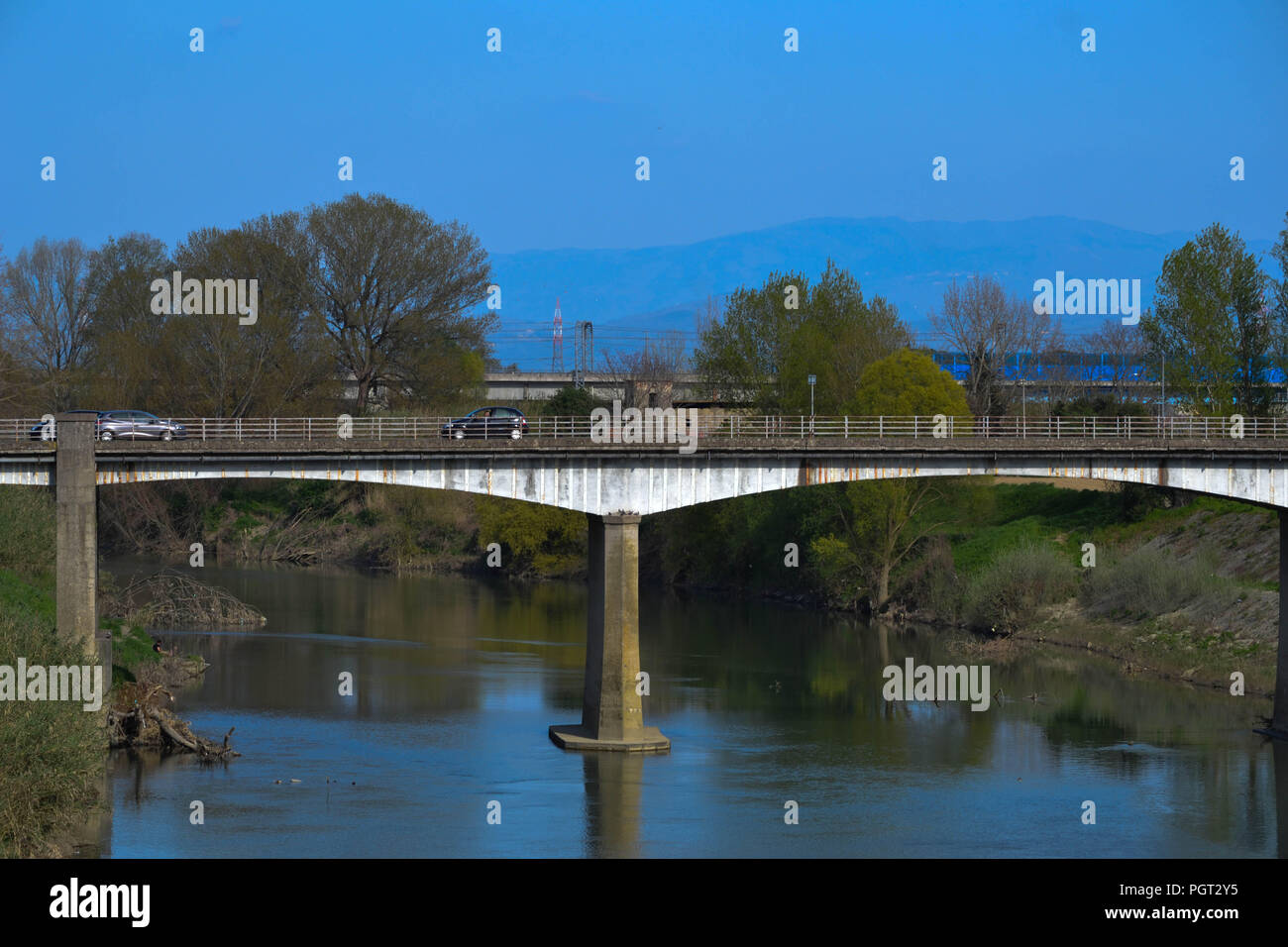 a bridge connecting two banks with cars passing over a crystalline ...