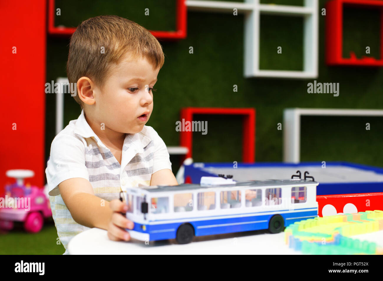 Cute boy playing with trolley car. Developing toys Stock Photo - Alamy
