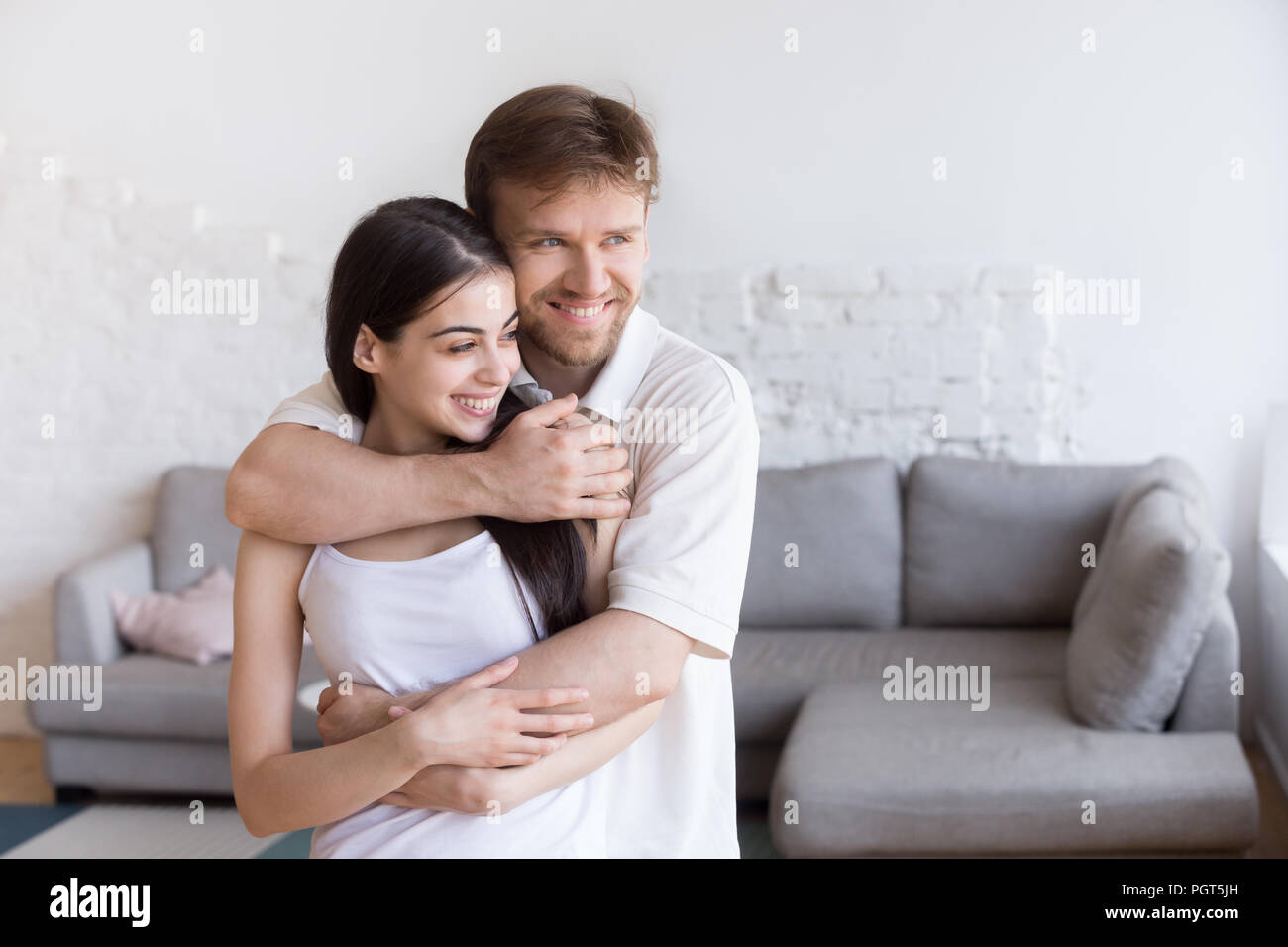 Portrait of happy young family dreaming about future together Stock ...