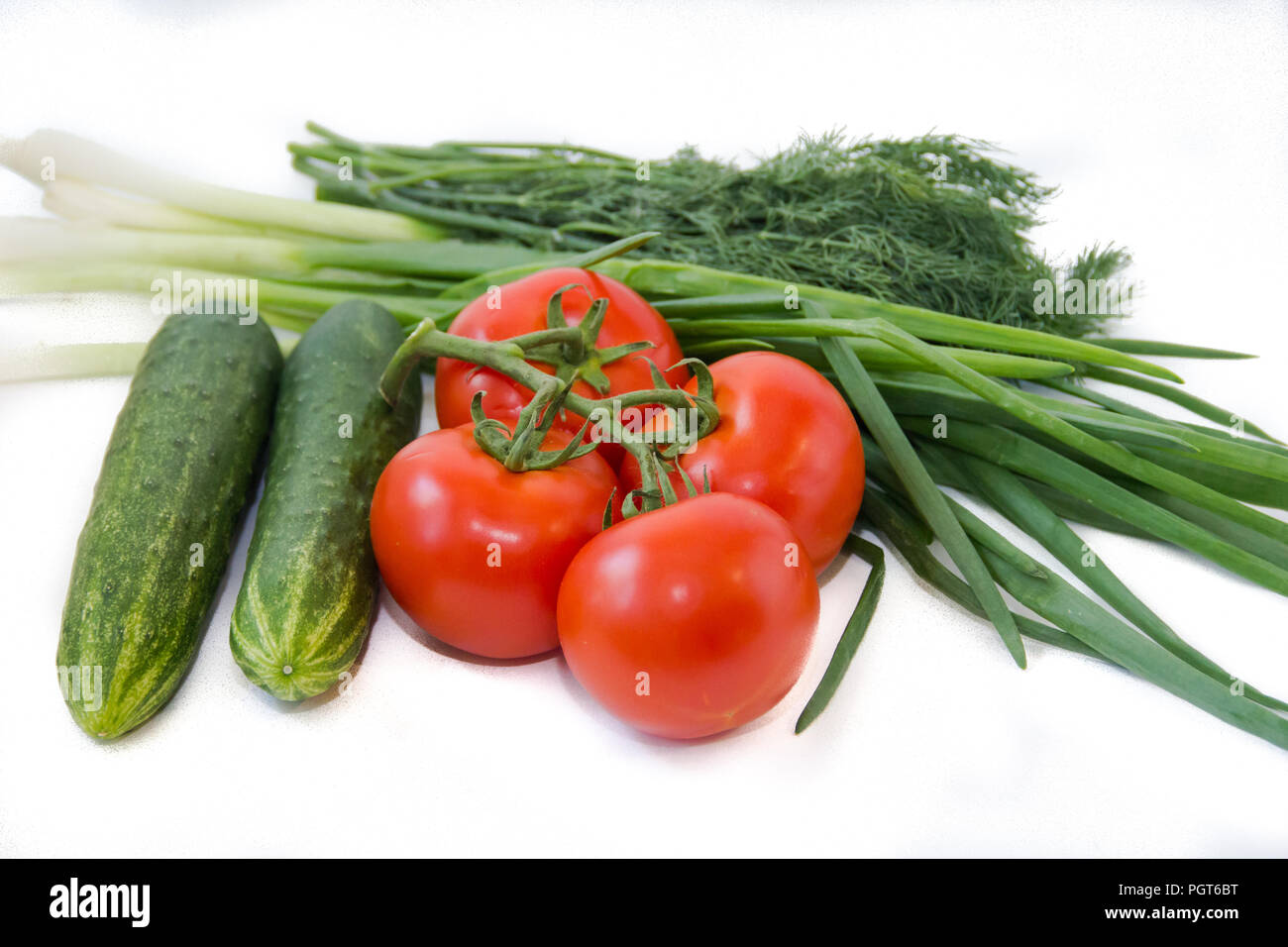 Tomatoes on a branch and cucumbers and greens isolated on white ...