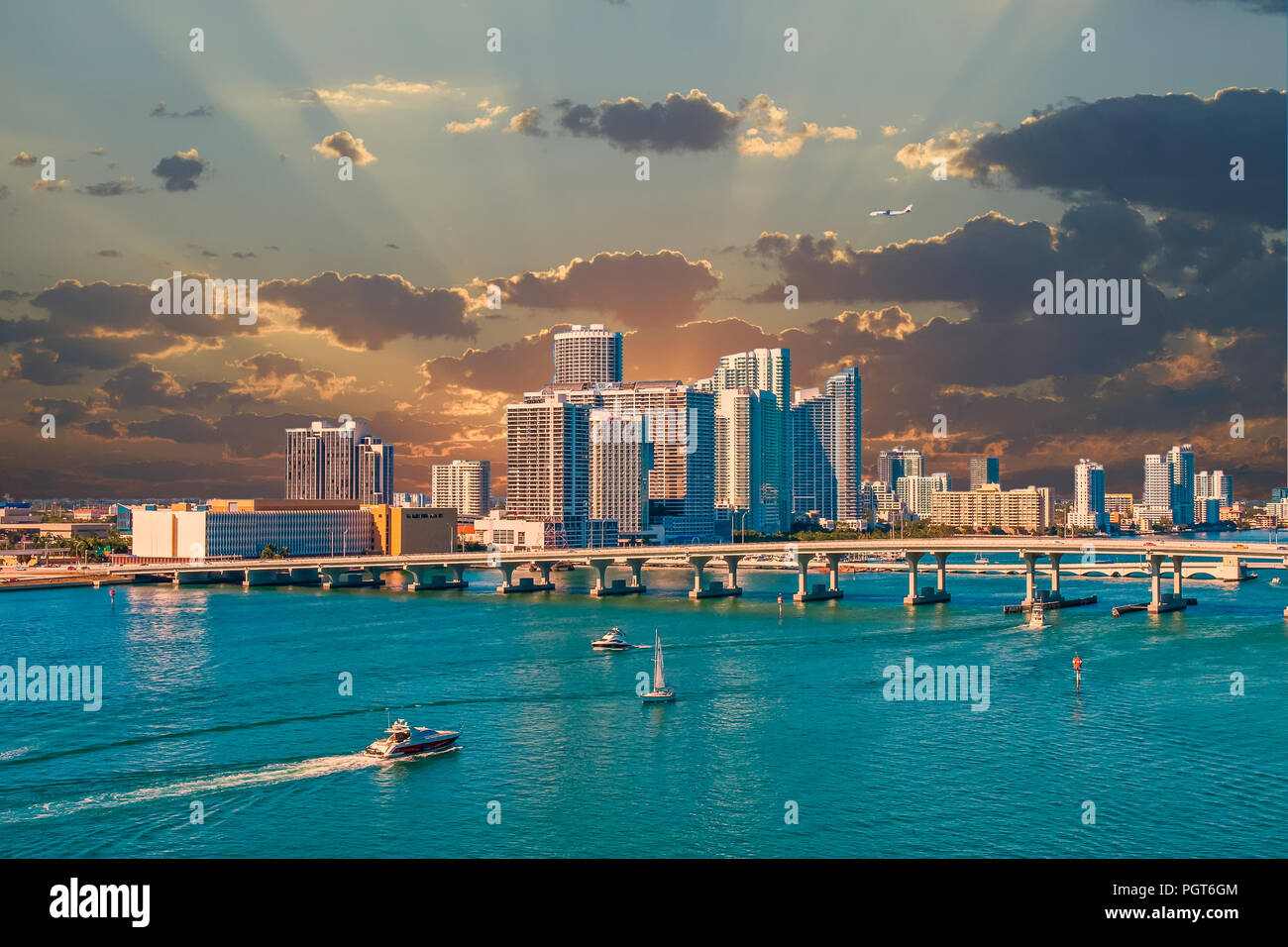 Miami's Biscayne Bay with a commercial jet overhead and boats sailing ...