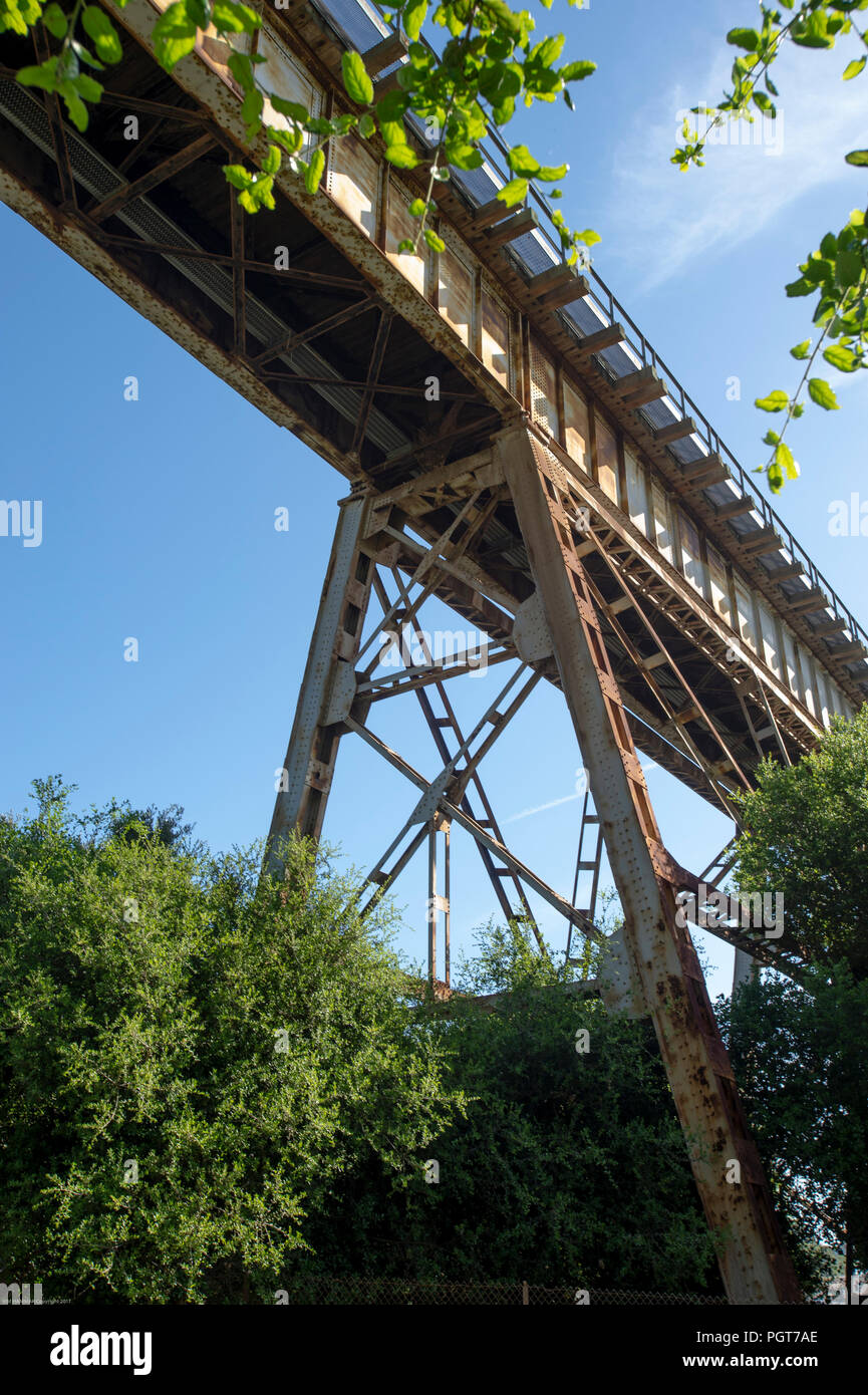 A view of the underside of a train trellis is highlighted by blue sky ...