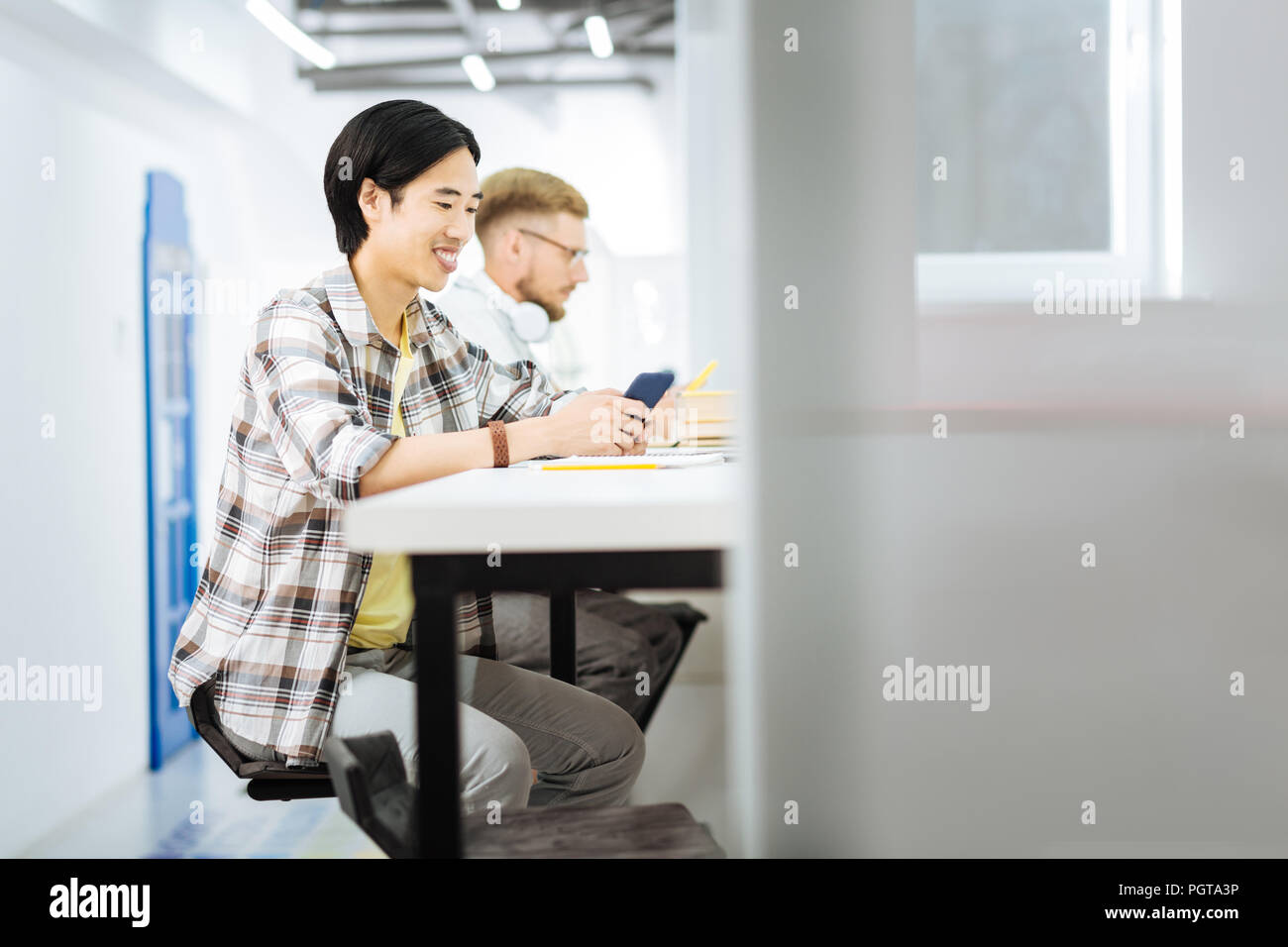 White coworking space with two men sitting separately Stock Photo - Alamy