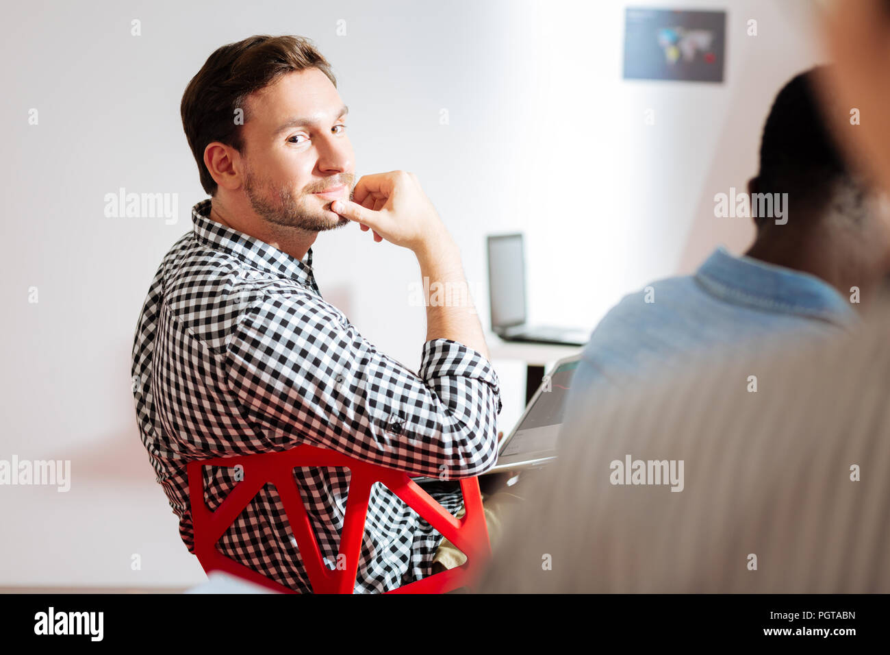 Handsome young man feeling interested and thoughtfully touching his ...