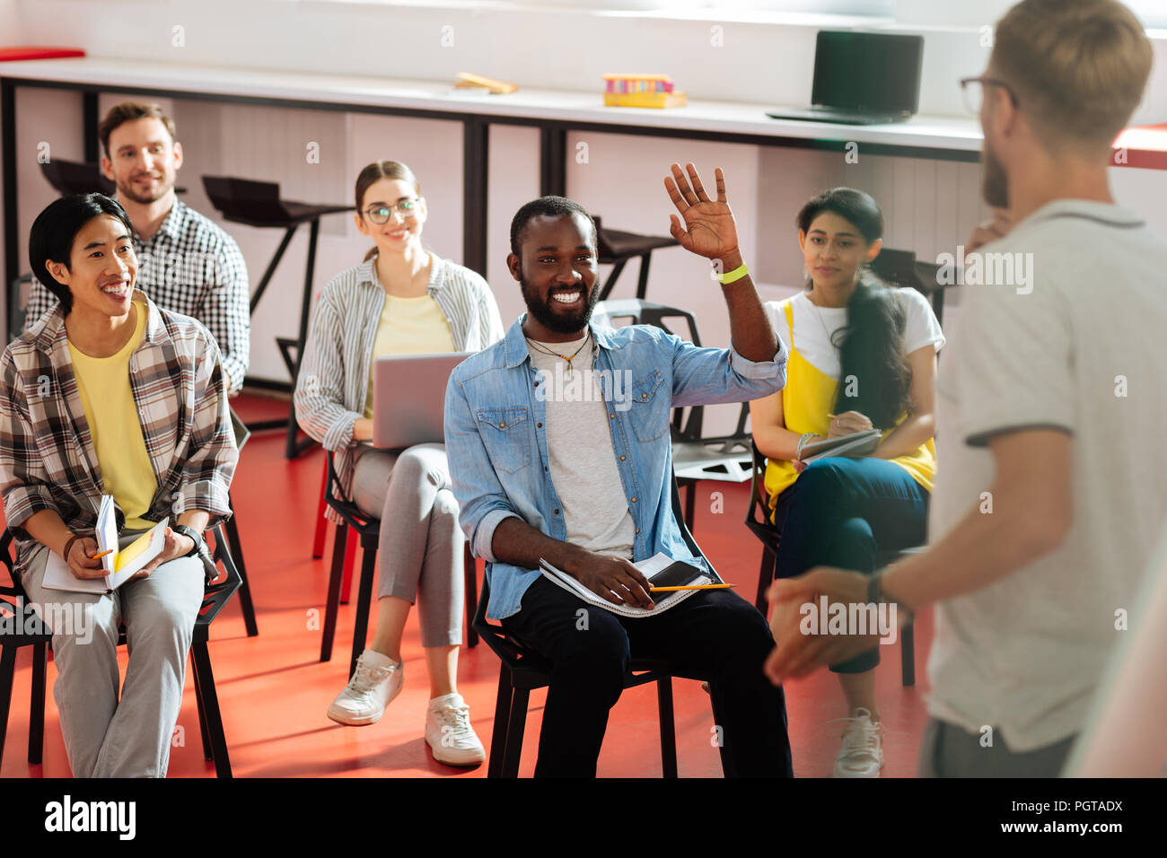 Active student raising his hand and looking ready to answer the ...