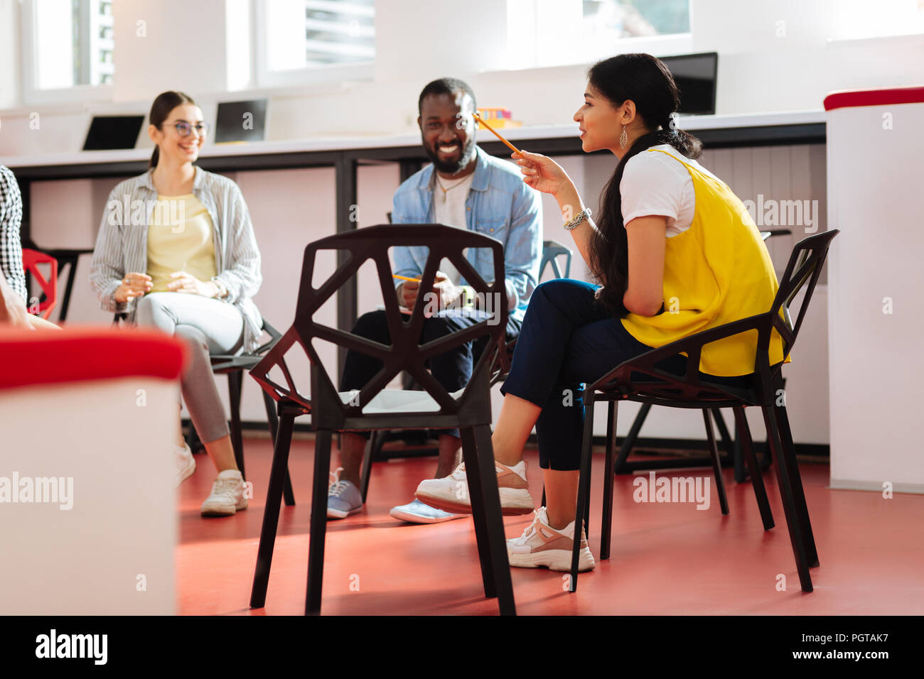 Group of friendly people sitting in circle and having a pleasant talk ...