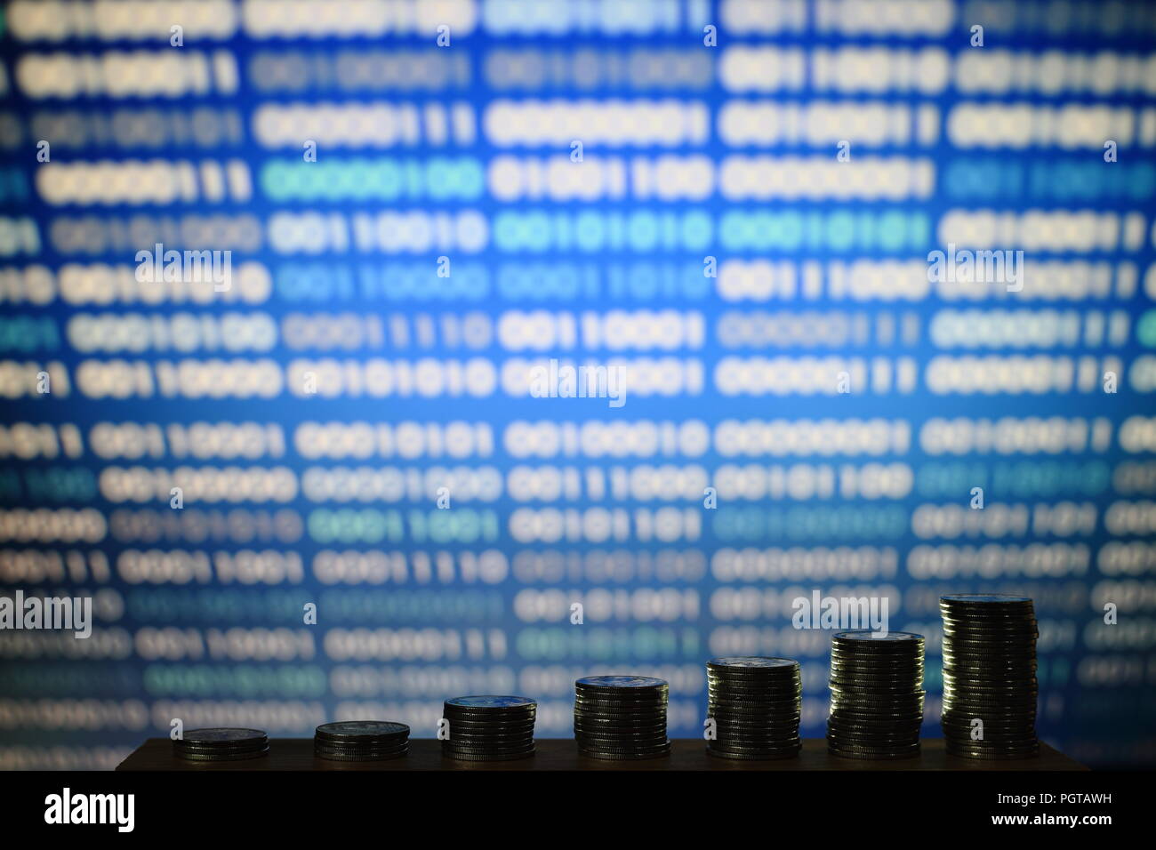 secured internet business. big coin piles in front of blue binary code ...
