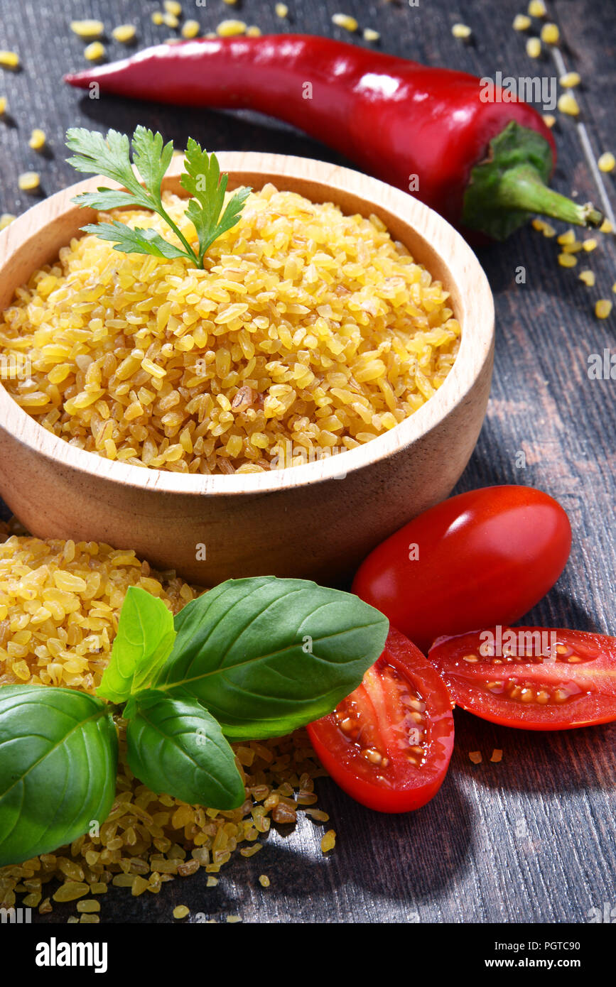 Bowl of uncooked bulgur on wooden table Stock Photo - Alamy