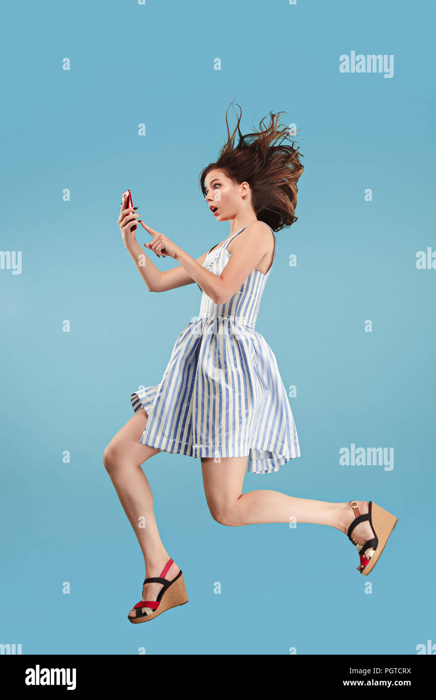 always on mobile. Full length of pretty young woman taking phone while ...