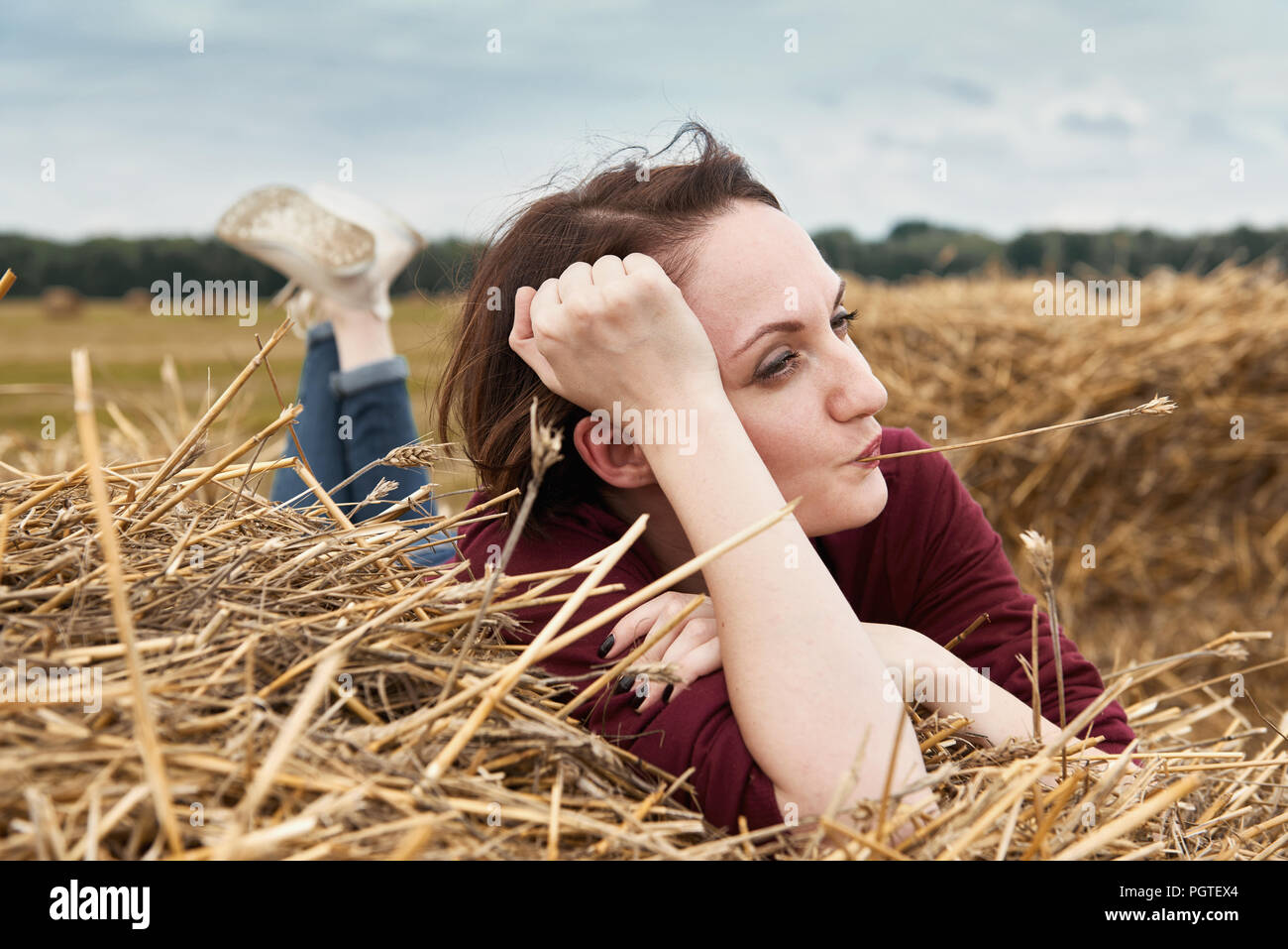 young girl having fun in the field, lying on a haystack Stock Photo - Alamy