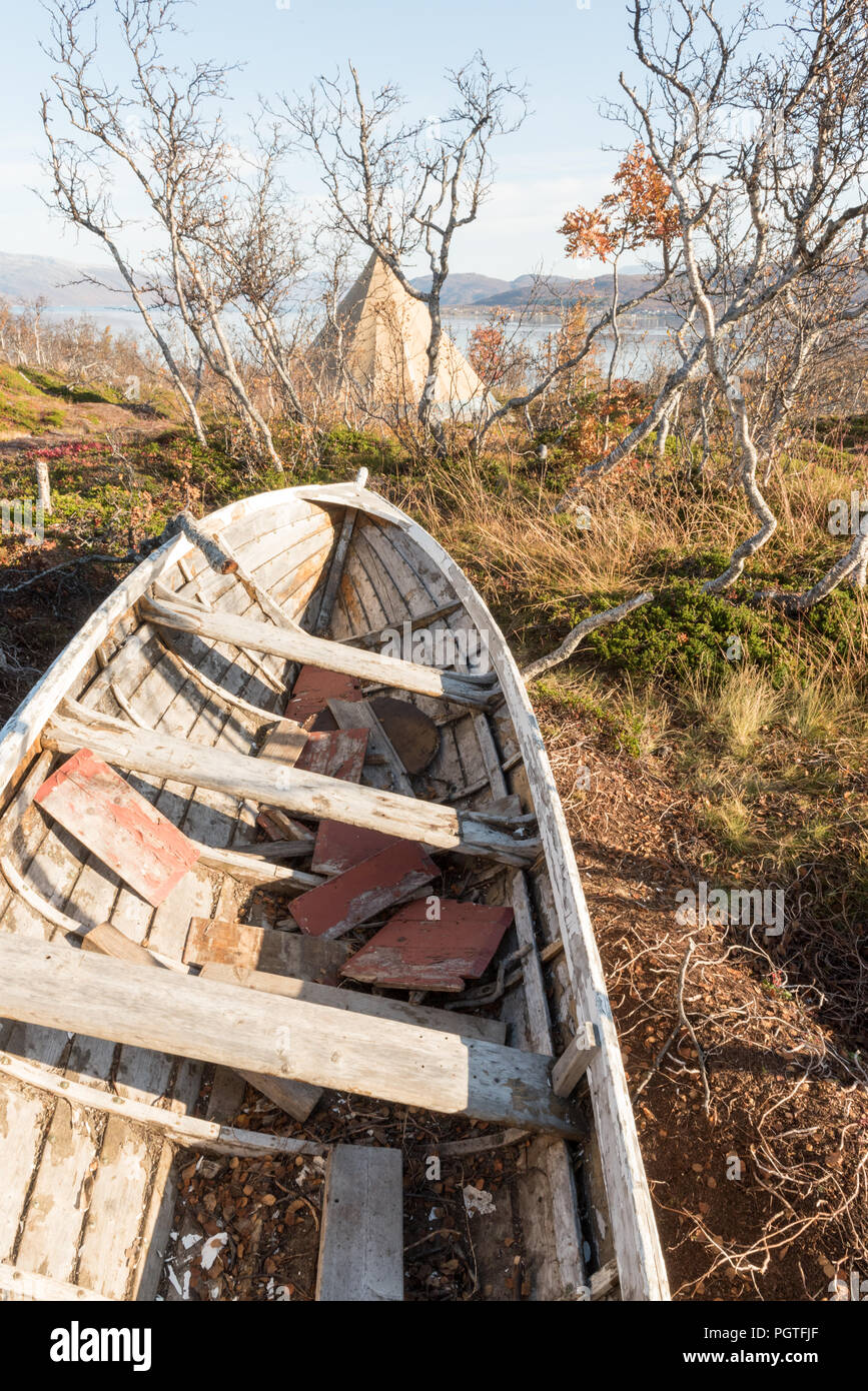 Old wooden dinghy rowboat beached on grass viewed close up on the prow ...
