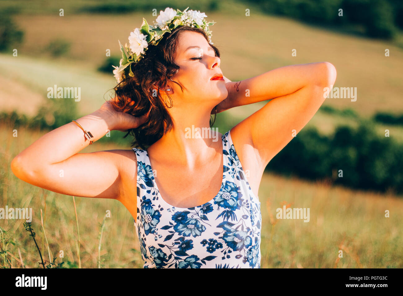 Girl with flower crown posing in the field during sunset Stock Photo ...