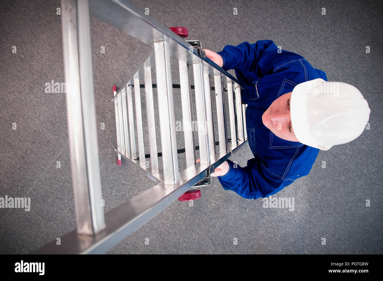 worker in a white helmet, enters the ladder Stock Photo - Alamy