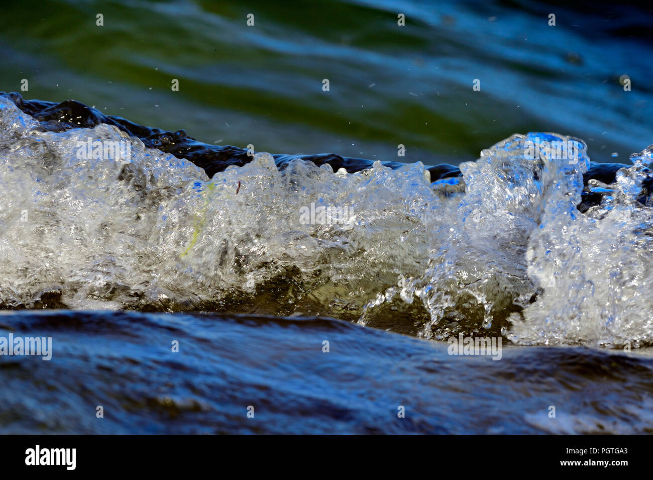 A close up image of an ocean wave breaking onshore with the incoming ...