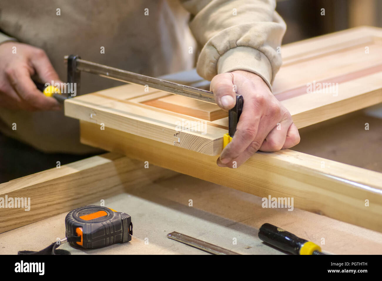 Manual manufacturing of furniture from a natural tree in a workshop ...