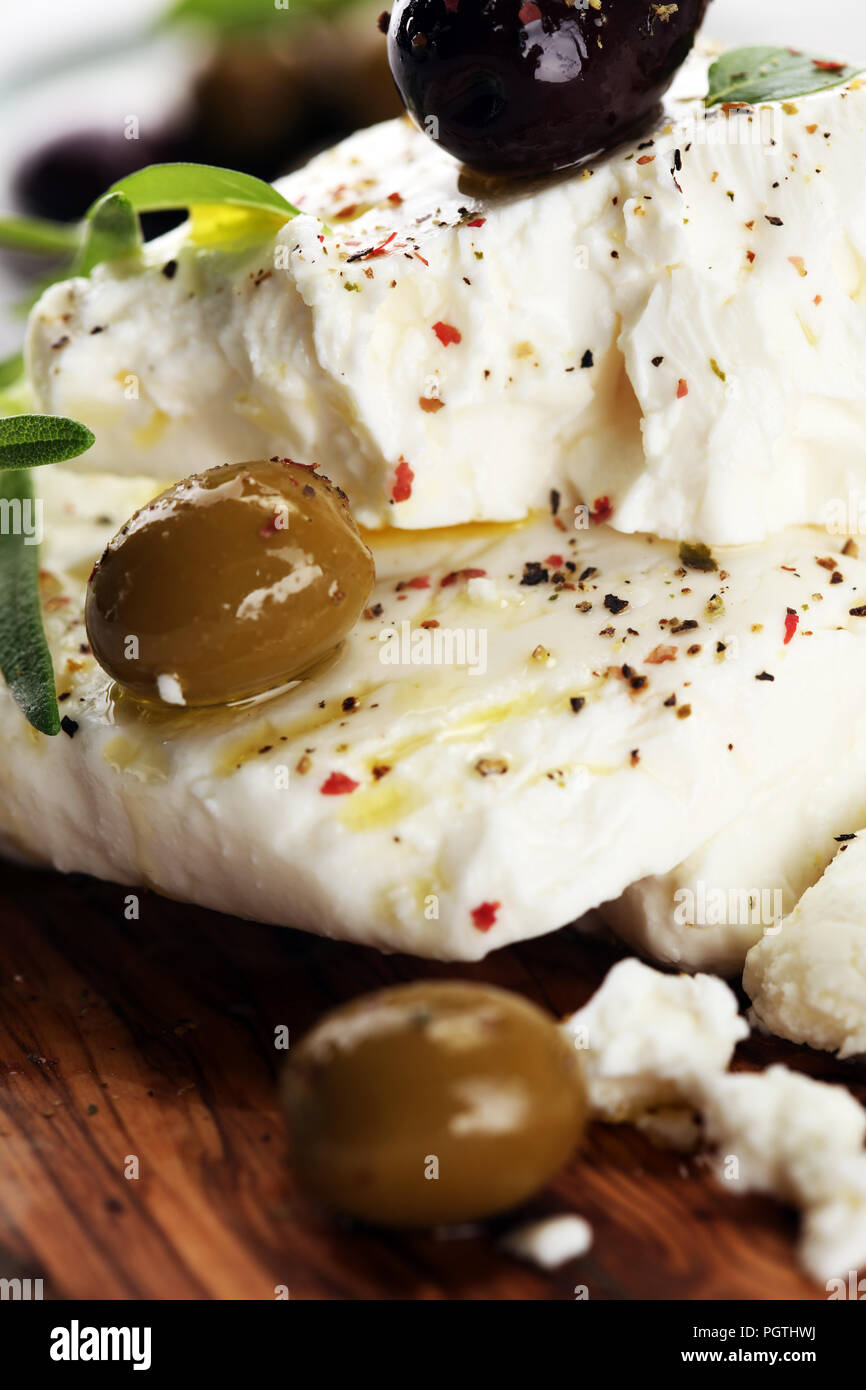 Greek cheese feta with herbs and olives on rustic table Stock Photo - Alamy