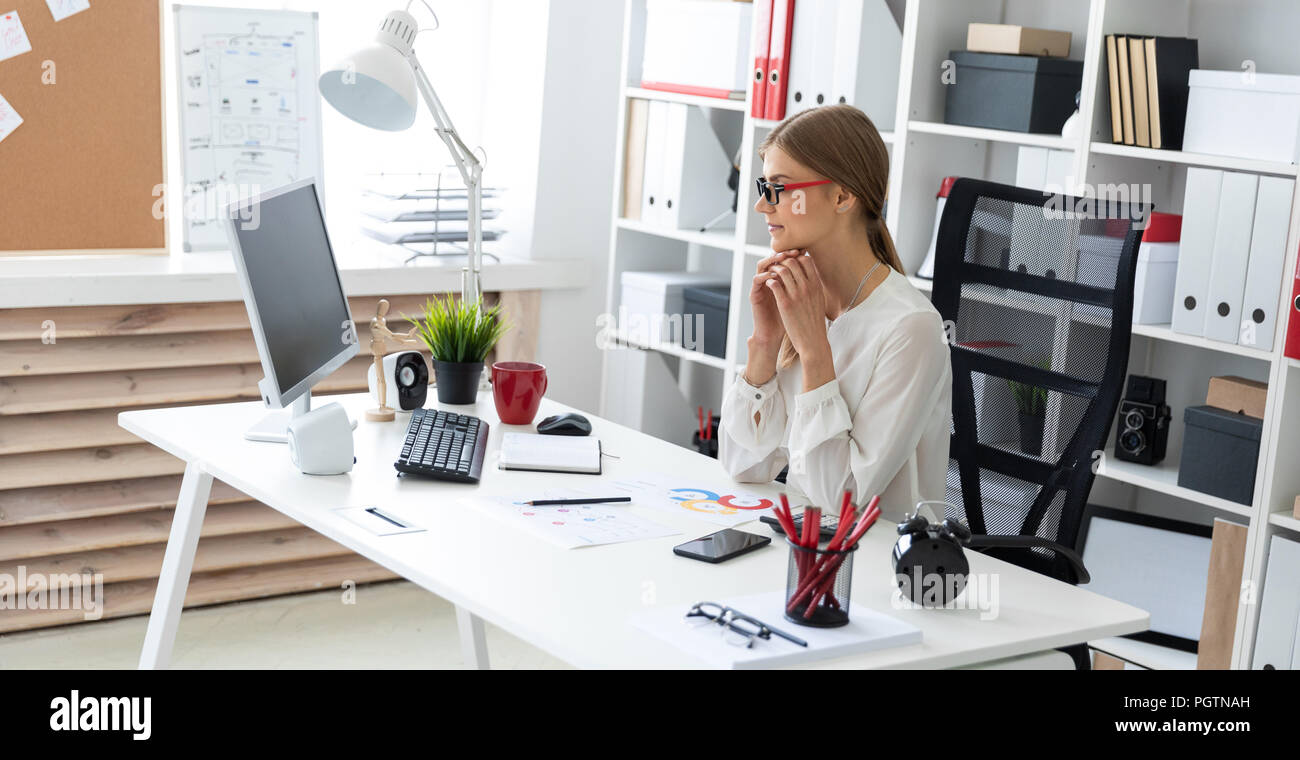A young girl is sitting at the computer desk in the office Stock Photo ...