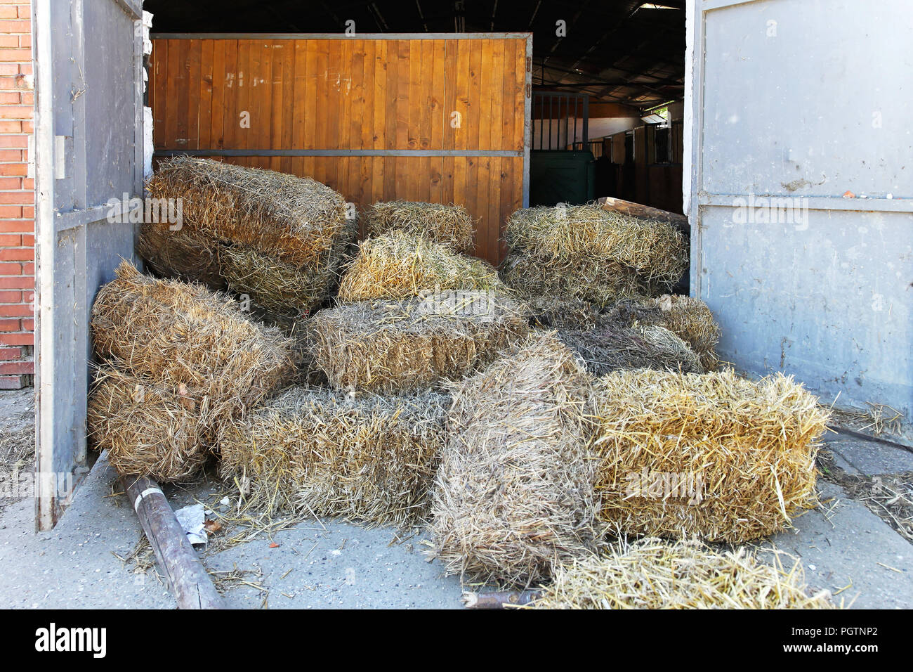 Square bale hay in front of stables Stock Photo - Alamy
