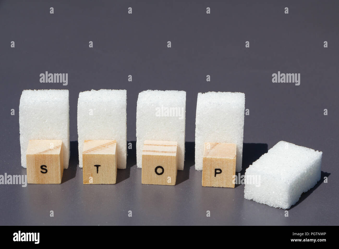 Stop written in wooden letters and five sugar cubes Stock Photo - Alamy
