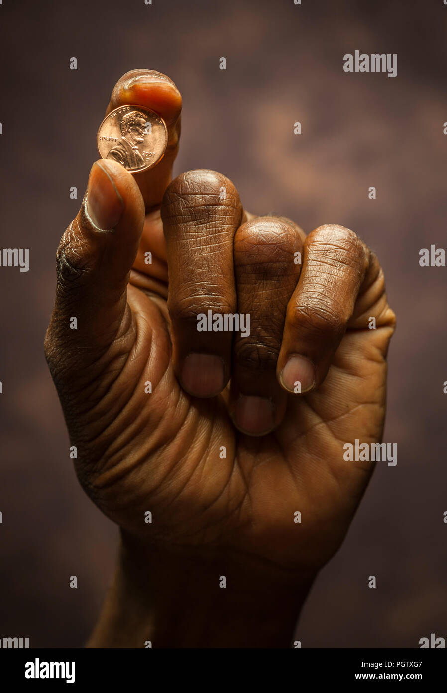 A black african hand holding a penny Stock Photo - Alamy