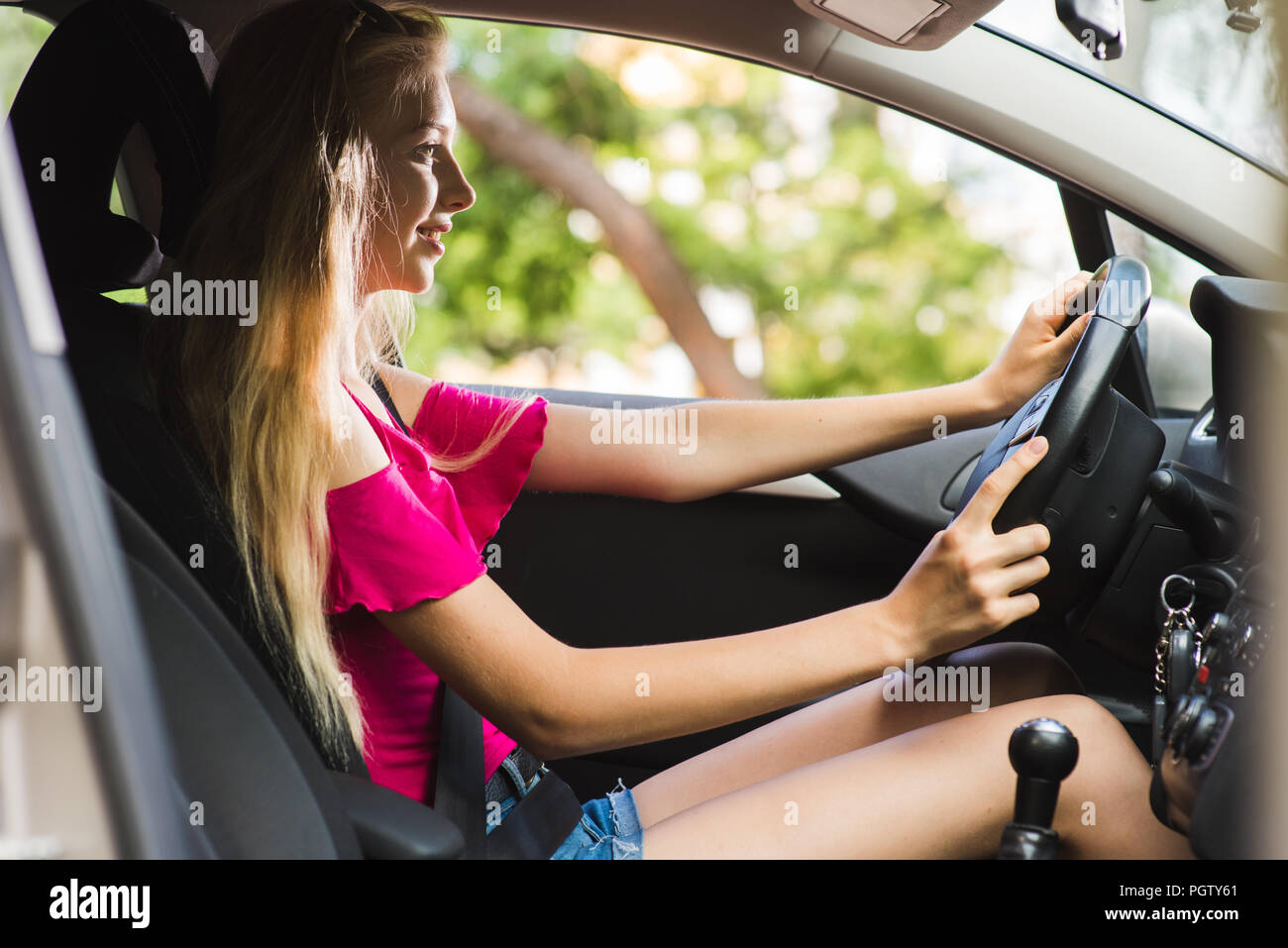 Picture of young female driving and smiling Stock Photo - Alamy
