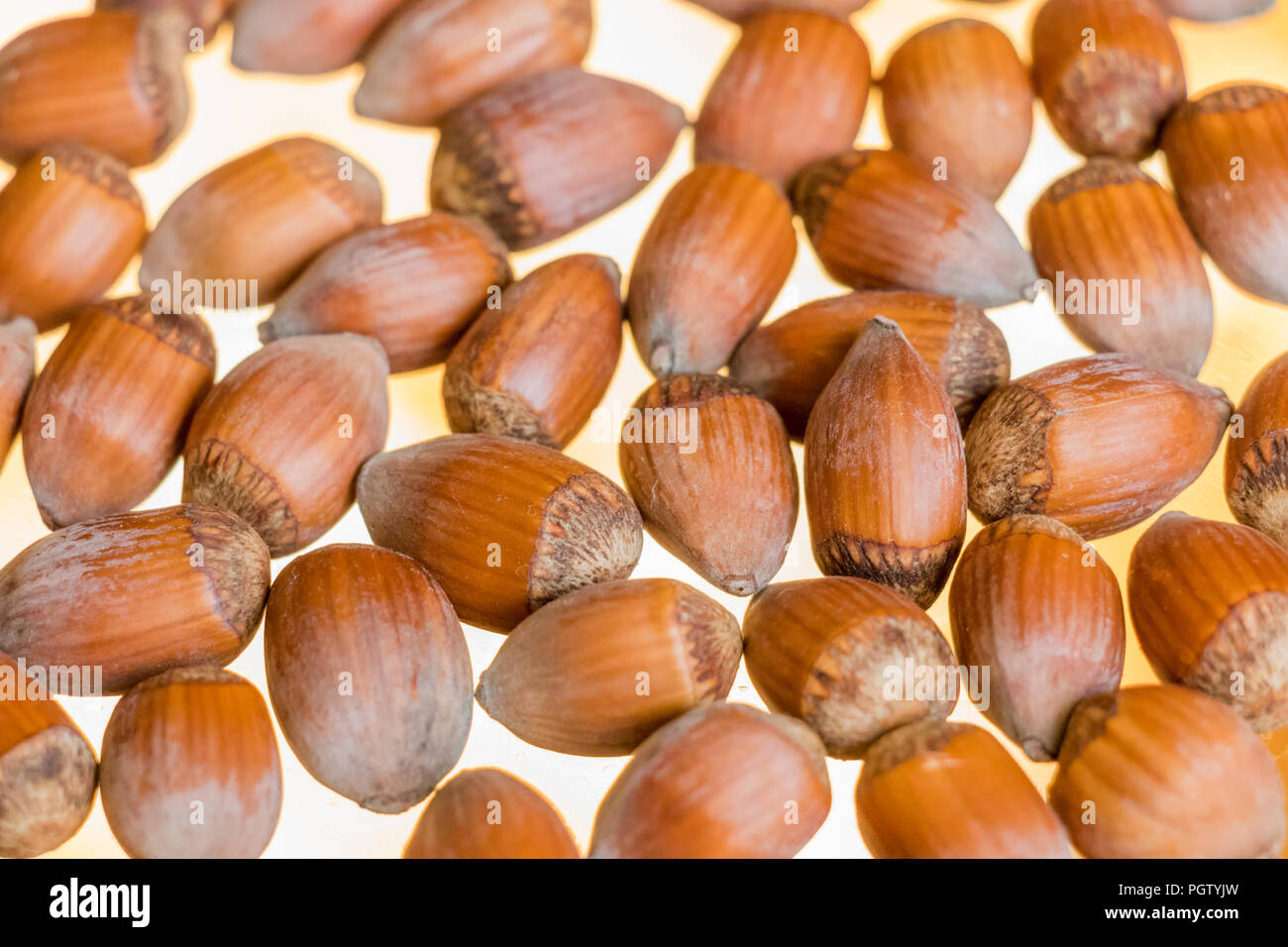 Stack of hazelnut with blur yellow background Stock Photo - Alamy