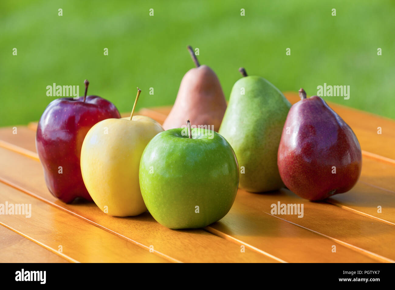 A variety of apples and pears lined up together on a table Stock Photo ...