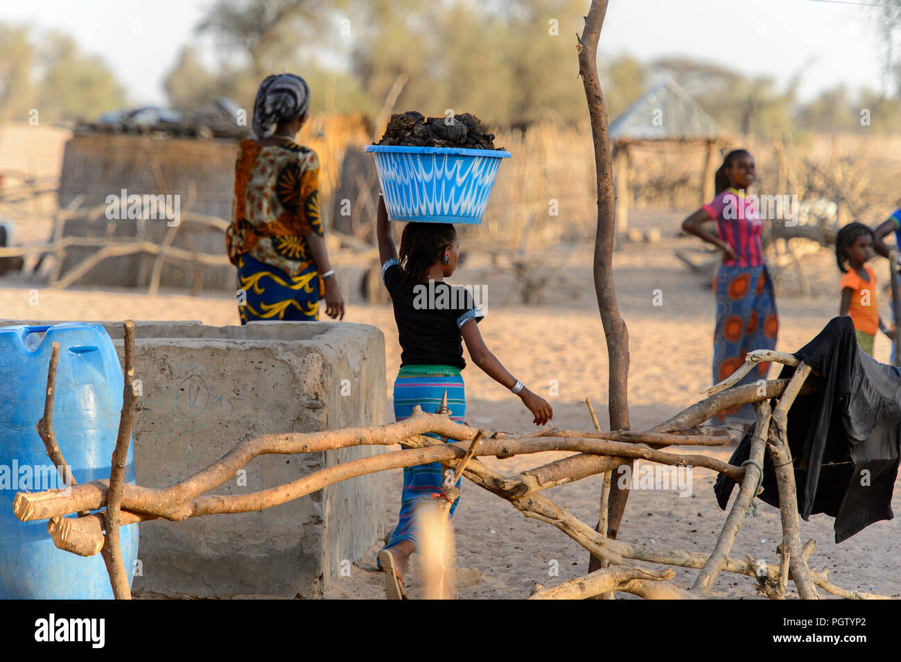FERLO DESERT, SENEGAL - APR 25, 2017: Unidentified Fulani woman carries ...