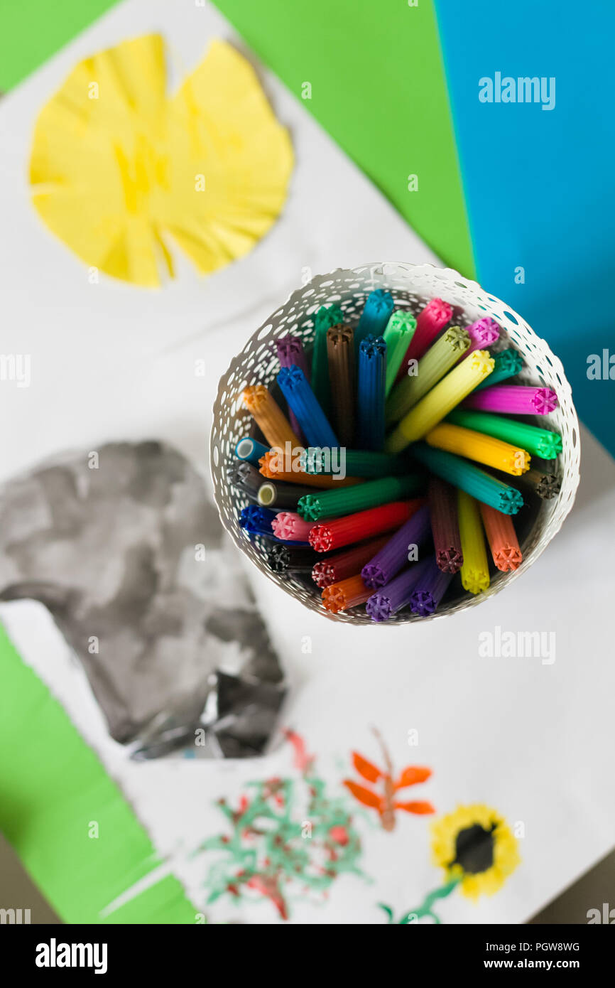 Set of bright colorful pens in a white pot with a child's drawing ...