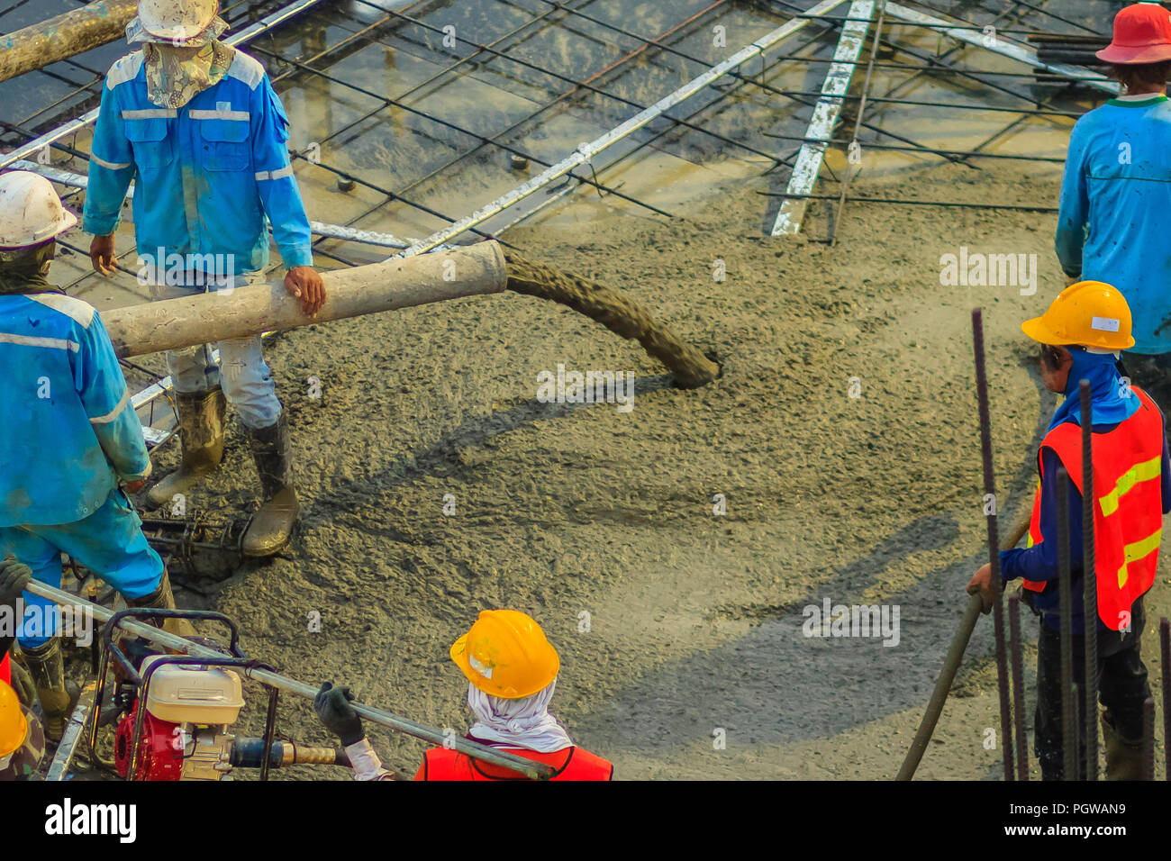 Construction workers are pouring concrete in post-tension flooring work ...