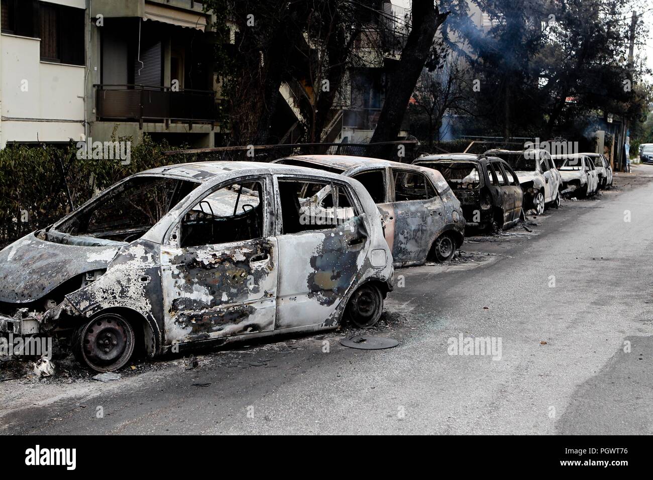 People stand amid the charred remains of burned-out cars in Mati east ...