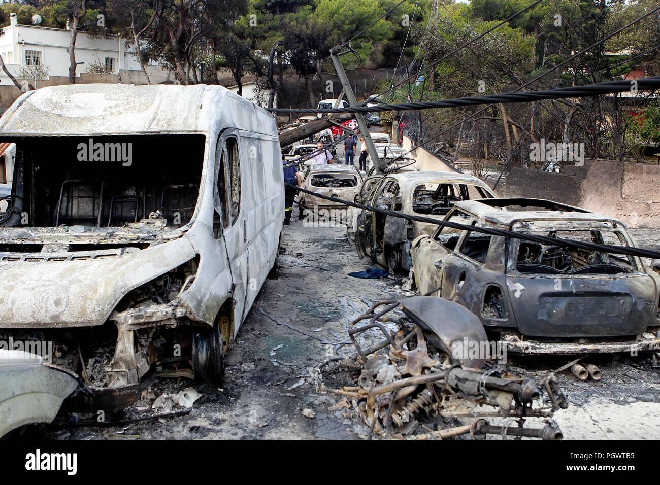 People stand amid the charred remains of burned-out cars in Mati east ...
