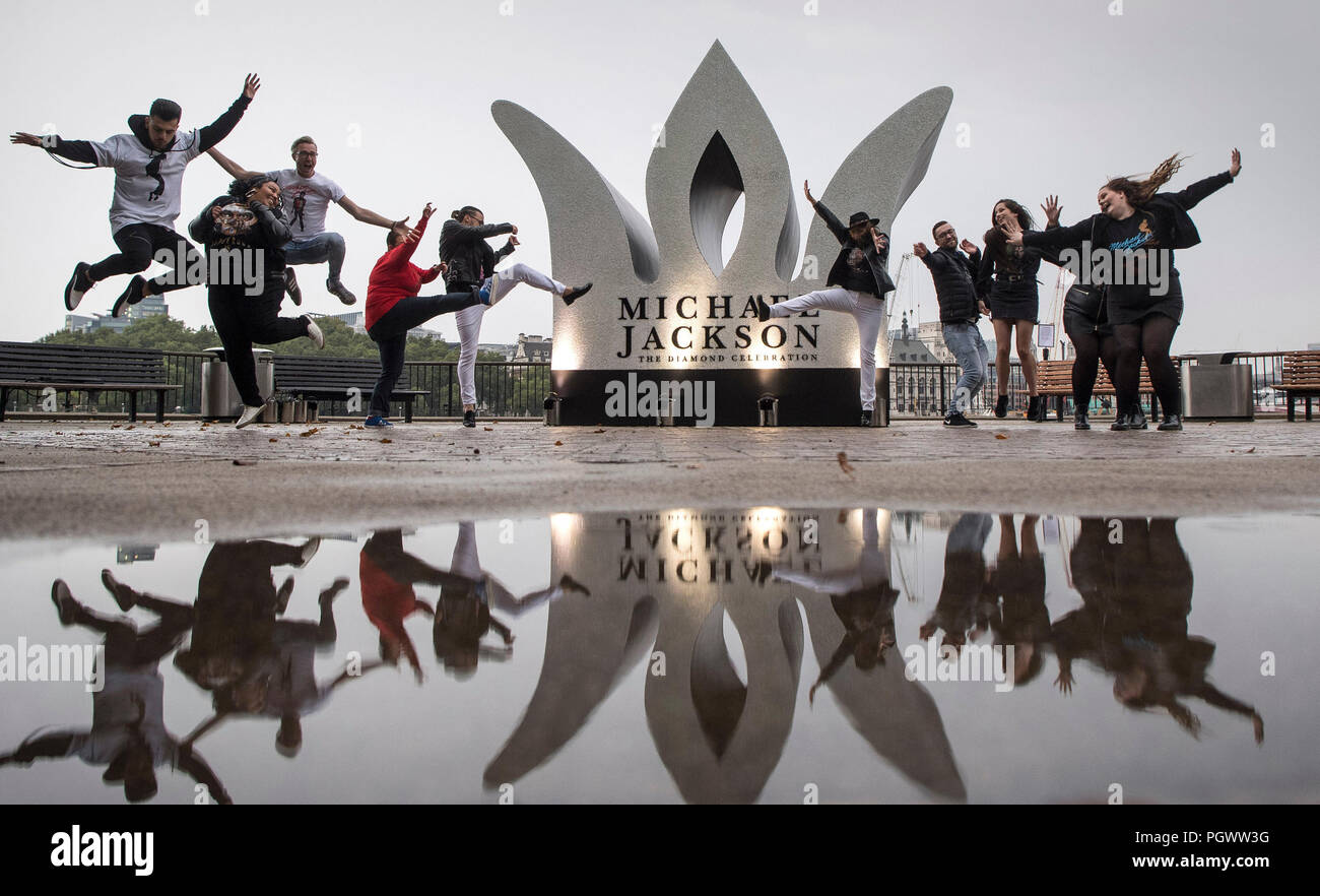 Michael Jackson fans pose with a thirteen foot high jewelled crown ...