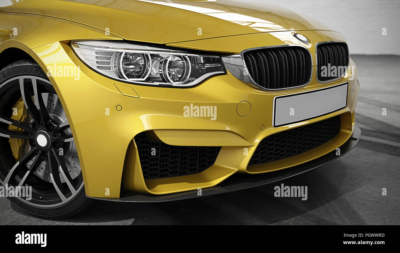 A fragment of a modern yellow car in the garage. 3D rendering. Facade ...