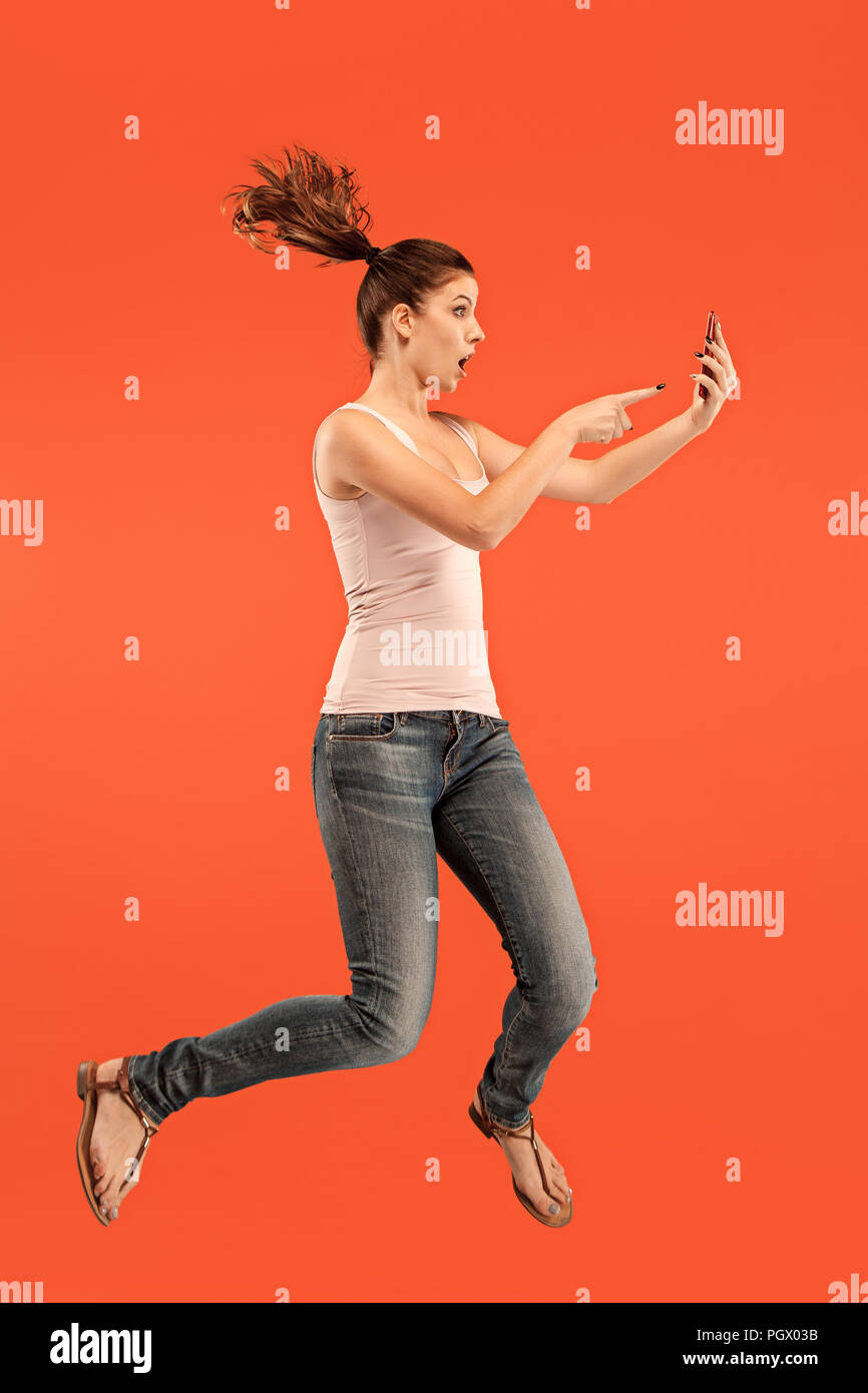 always on mobile. Full length of pretty young woman taking phone while ...