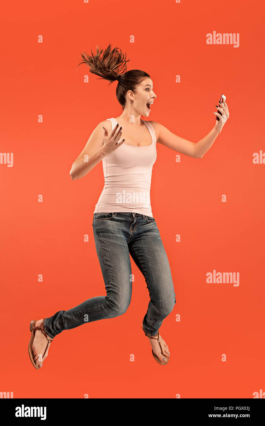 always on mobile. Full length of pretty young woman taking phone while ...