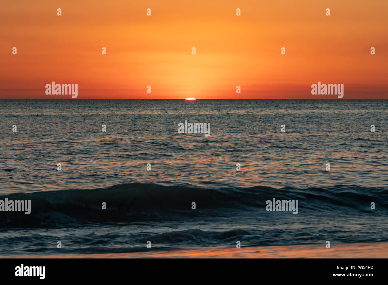 An orange sunset on a clear night over the ocean in Perth Western ...
