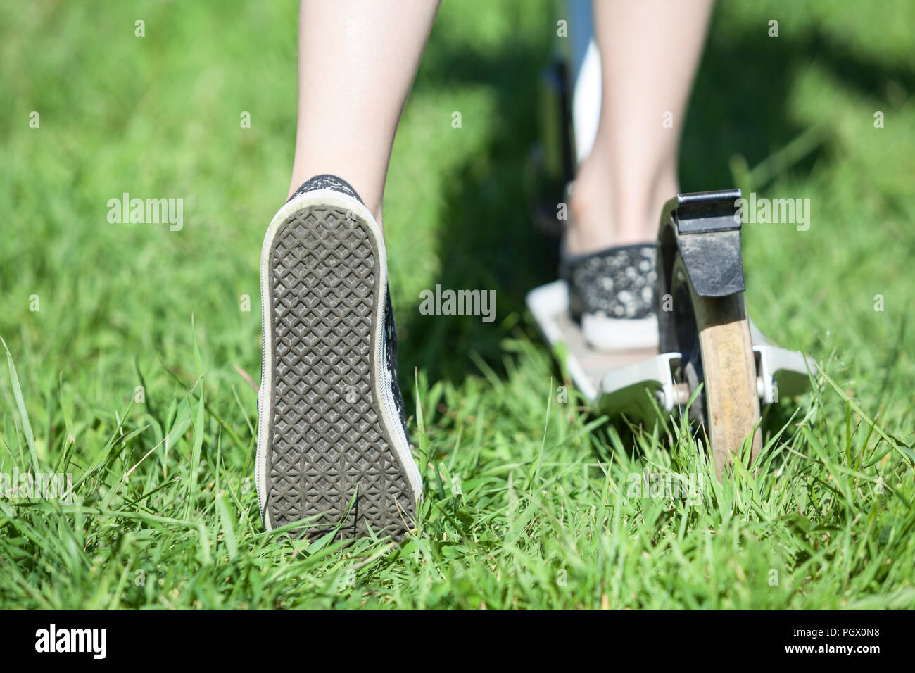 Children feet wearing rubber shoes pushing while riding balance bicycle ...