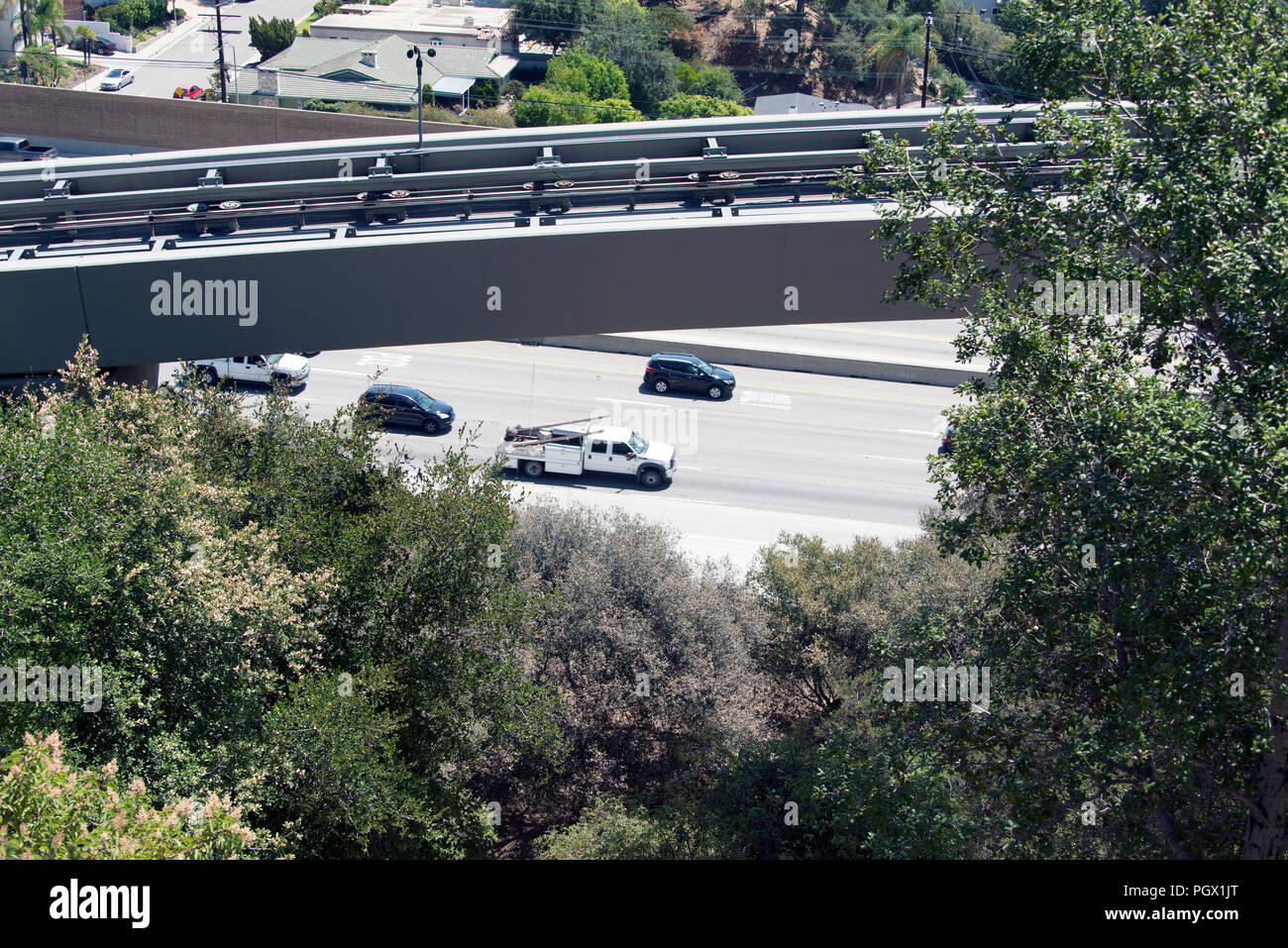A view of an elevated tram rail and a highway passing cars in Los ...