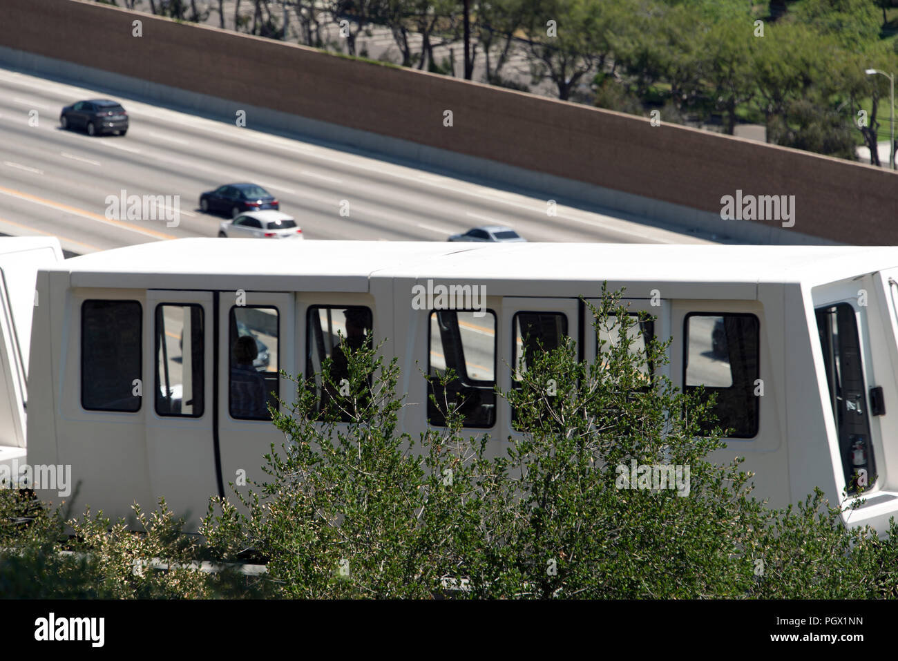 A view of an elevated tram rail and a highway passing cars in Los ...