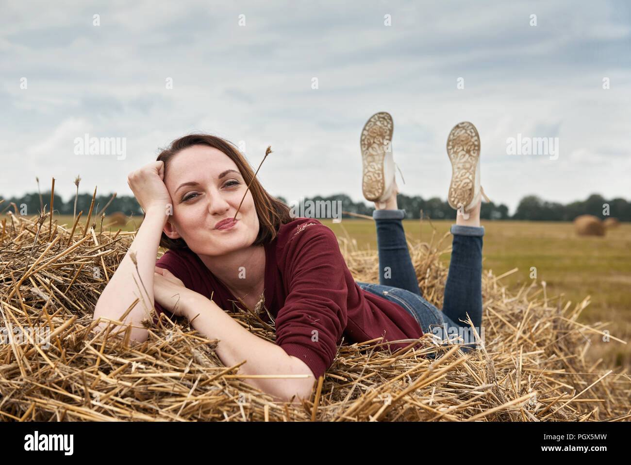 young girl having fun in the field, lying on a haystack Stock Photo - Alamy
