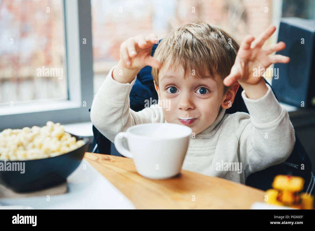 Portrait of cute adorable Caucasian child kid boy drinking milk from ...