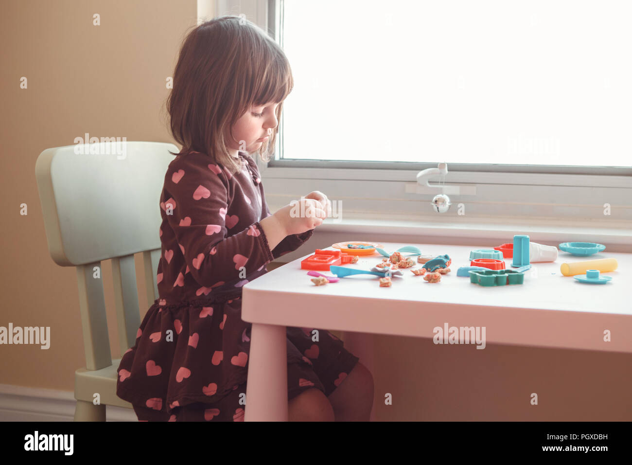 Portrait of cute white Caucasian preschooler girl playing plasticine ...