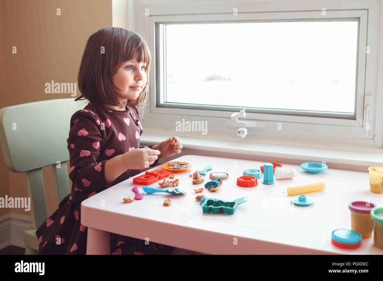 Portrait of cute white Caucasian preschooler girl playing plasticine ...