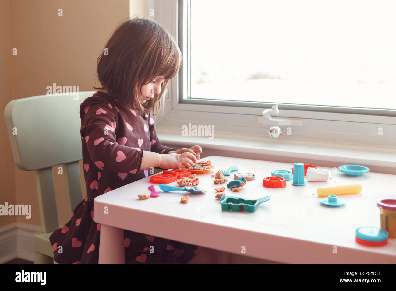Portrait of cute white Caucasian preschooler girl playing plasticine ...